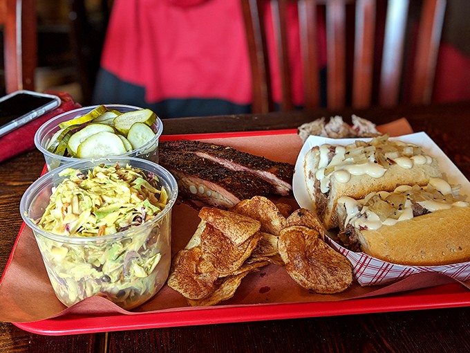 A tray of happiness featuring slaw, pickles, and a sandwich that makes you wonder why you ever ate anything else.