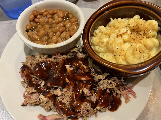 A holy trinity of barbecue bliss: pulled pork drizzled with sauce, beans rich with smoky depth, and mac and cheese that could make a grown adult weep.