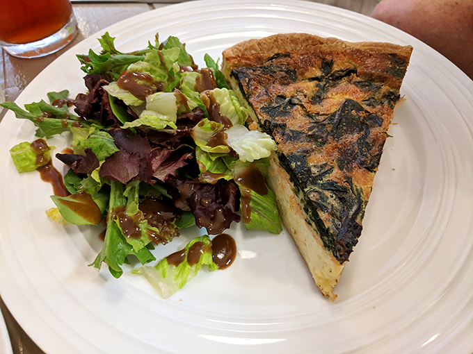 A slice of quiche that's having a meaningful relationship with that salad. They complete each other, like peanut butter and jelly for grown-ups.