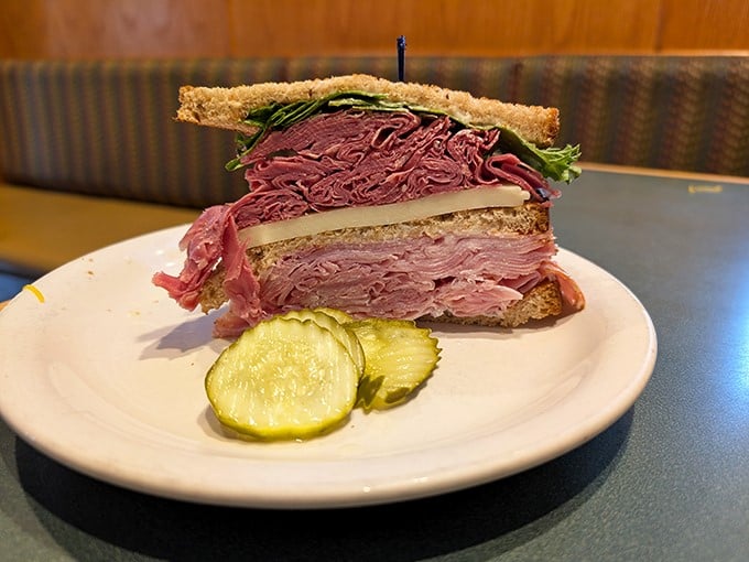 This isn't just a sandwich; it's a skyscraper of corned beef architecture that would make Manhattan jealous. The pickle is your support beam.