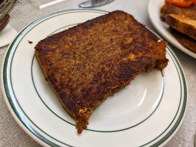 Perfectly seared and caramelized, this slice of scrapple is the diner's unsung hero&mdash;crispy exterior giving way to a savory interior that defies description.