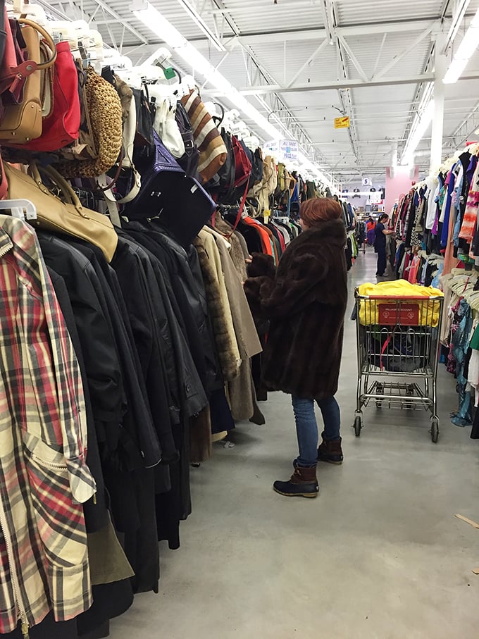 The serious thrifter in their natural habitat—methodically hunting through winter coats like a detective solving the case of the missing style.