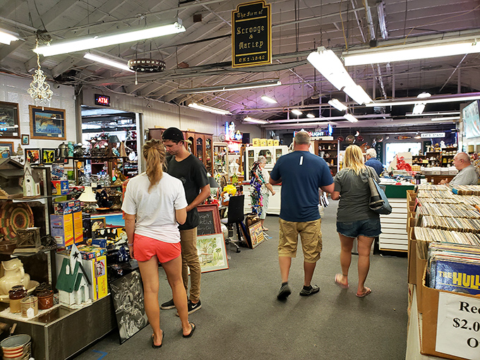 The universal flea market stance: that contemplative posture of shoppers deciding if they've found their perfect treasure or should keep hunting.