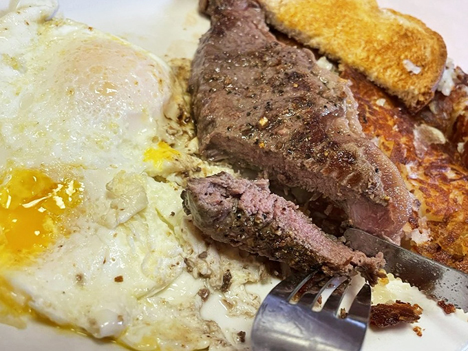 A steak cooked exactly how humans have craved it since discovering fire, sitting beside an egg that's having its best day.