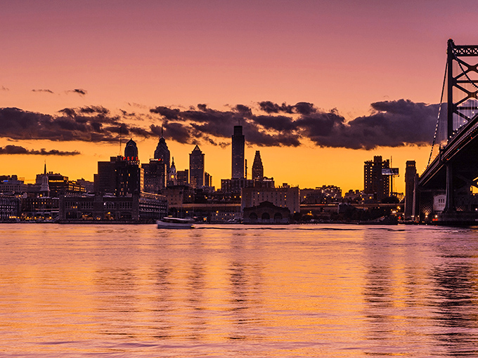 Sunset transforms the Delaware River into liquid gold, offering Camden residents a daily light show that rivals expensive entertainment in neighboring cities.