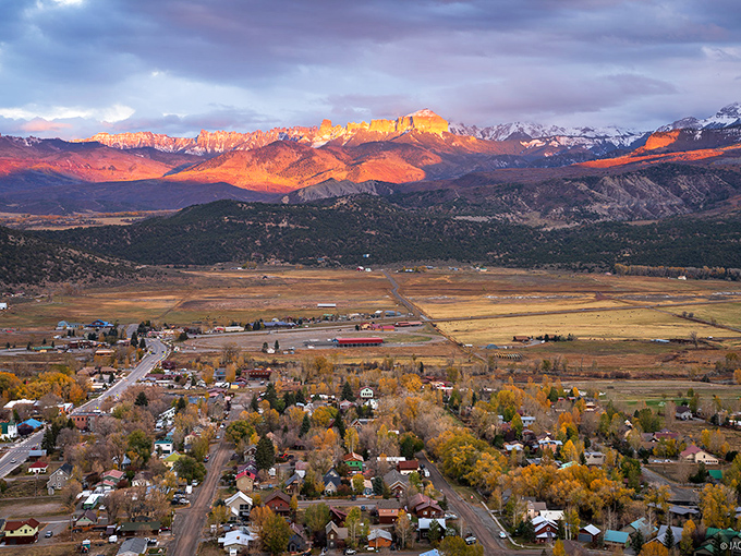 Mountains ablaze with sunset light create a backdrop that makes even non-photographers reach for their phones. Nature's version of mood lighting transforms the valley into pure magic.