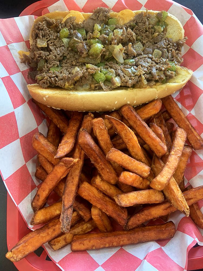 Sweet potato fries that could make a French chef weep with joy, paired with a sandwich that demands both hands and several napkins.