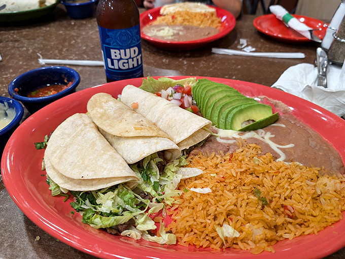 Tacos and burritos share the spotlight on this fiesta of a plate. The fresh avocado slices add a buttery richness that perfectly complements the seasoned rice and beans.