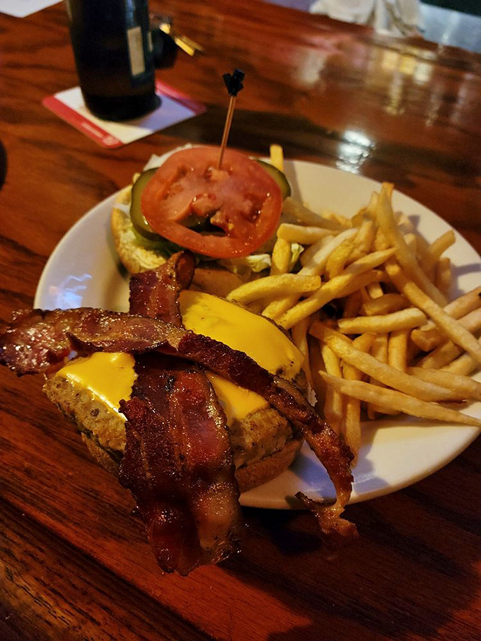 The Flying Pig in its natural habitat - bacon strips draped over a burger like they're sunbathing on the most delicious beach in Ohio.