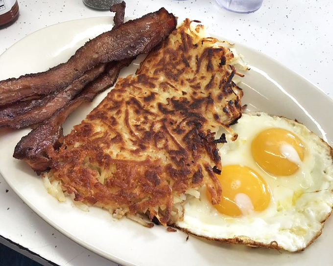 The holy trinity of breakfast perfection. Those sunny-side eggs with their perfect centers, crispy hash browns, and bacon cooked to that magical sweet spot.