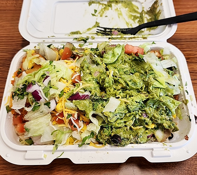 A fiesta in a box! This isn't just a salad—it's a celebration of freshness where guacamole takes center stage like the headliner at a rock concert.