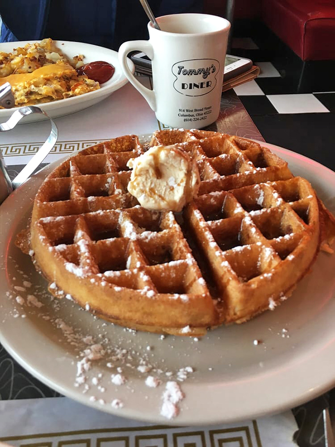 A waffle that understands its purpose in life &ndash; golden, crisp-edged perfection dusted with powdered sugar and crowned with a melting butter hat.