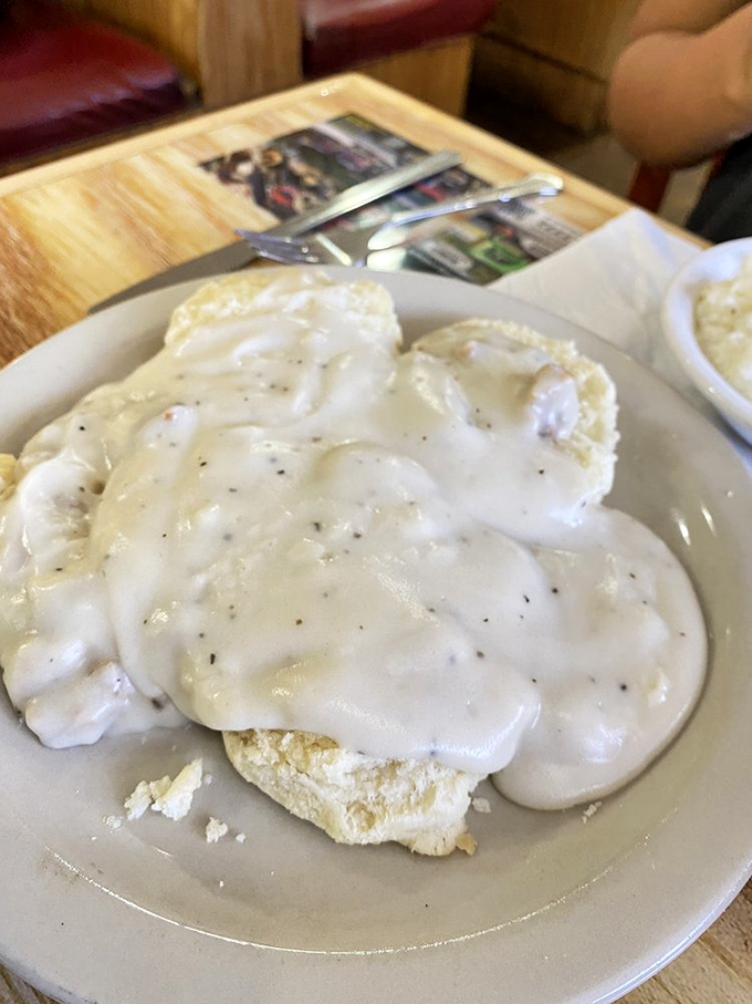 Biscuits and gravy that could make your grandmother question her own recipe. This cloud-like biscuit drowning in peppery cream gravy is the breakfast equivalent of a warm embrace.