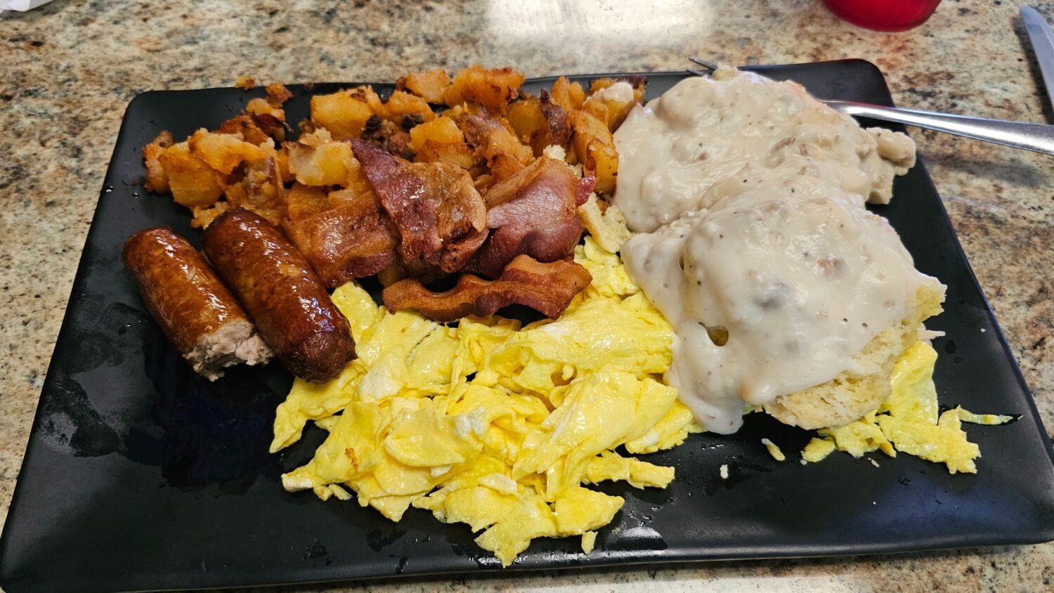 The breakfast of champions: sausage links glistening with promise, eggs scrambled to fluffy perfection, and biscuits smothered in gravy that would make your grandma jealous.