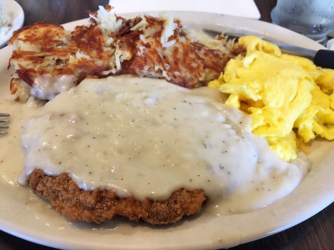 Country-fried steak swimming in peppery gravy alongside crispy hash browns&mdash;comfort food that hugs your soul before noon.