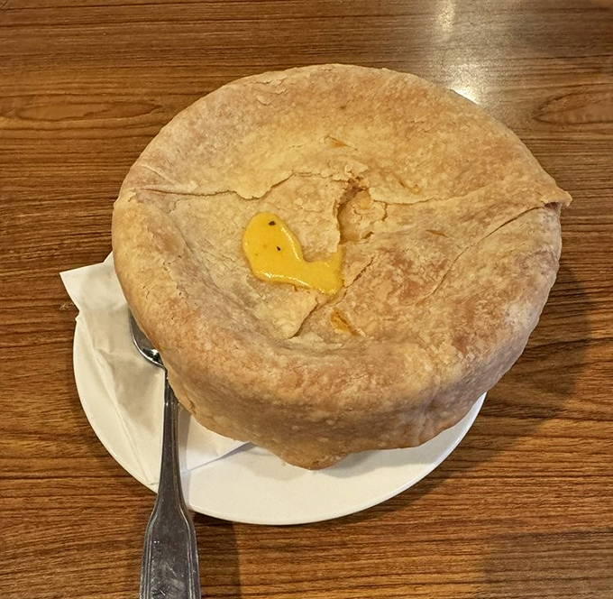 Beneath this golden-brown pastry fortress lies a savory treasure of chicken and vegetables&mdash;comfort food architecture at its finest.