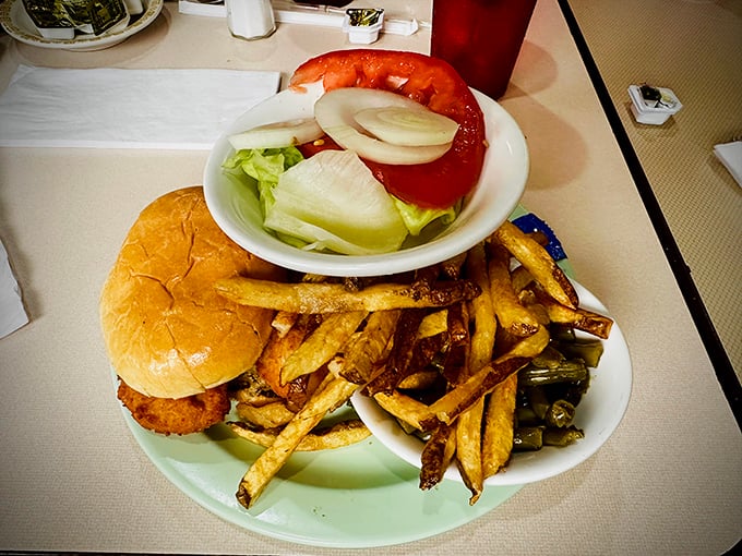 Sandwich architecture at its finest! This creation balances crispy chicken, garden-fresh toppings, and hand-cut fries&mdash;the holy trinity of lunch satisfaction.