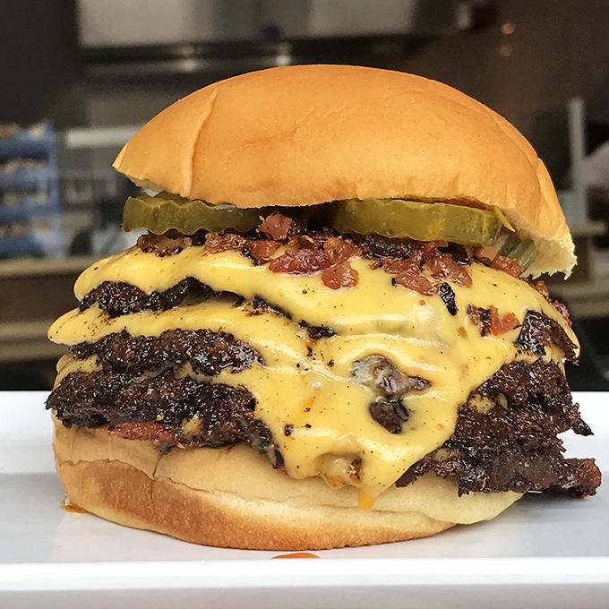 Triple the patties, triple the pleasure. This towering achievement of beef, cheese, and bacon makes skyscrapers jealous with its impressive, mouth-watering architecture.