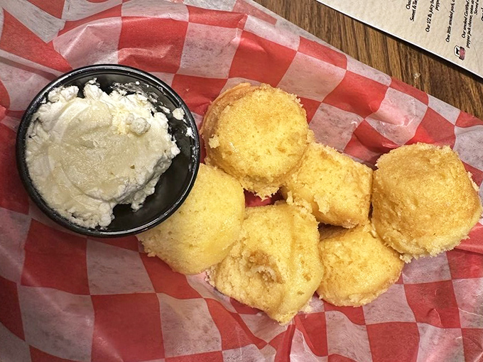 Golden cornbread muffins flanking a cloud of butter—a supporting act that frequently steals the show from the barbecue headliners.
