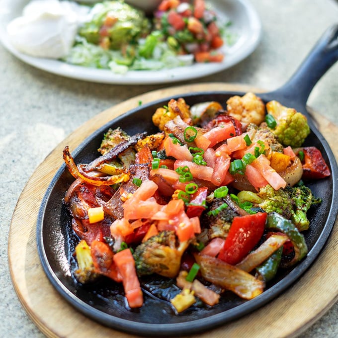 Sizzling fajitas that announce their arrival before you see them, topped with fresh pico de gallo that adds bright pops of color and flavor.