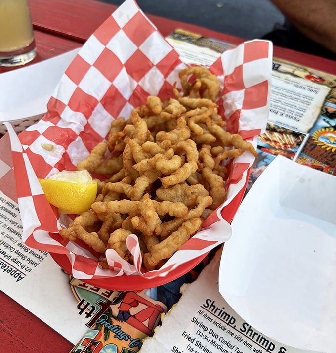 Golden fried clam strips that crunch like autumn leaves, served with a lemon wedge that's not just garnish&mdash;it's essential seasoning.