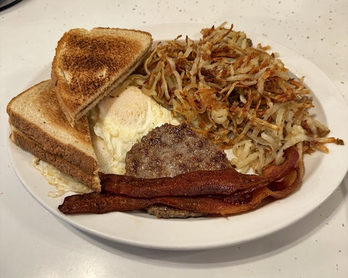 Breakfast perfection on a plate: golden hash browns with the ideal crisp-to-tender ratio, eggs cooked precisely to order, and bacon that means business.