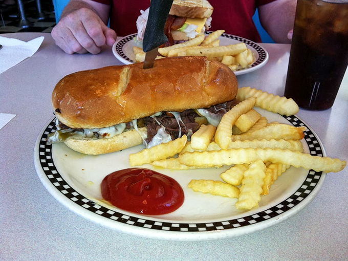 This isn't just a sandwich; it's an architectural marvel of beef, cheese, and bread that requires both hands and possibly a nap afterward.