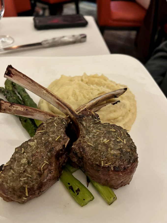 Lamb chops standing at attention like tiny meat soldiers, ready to march straight into flavor heaven. That mashed potato pillow looks equally dreamy.