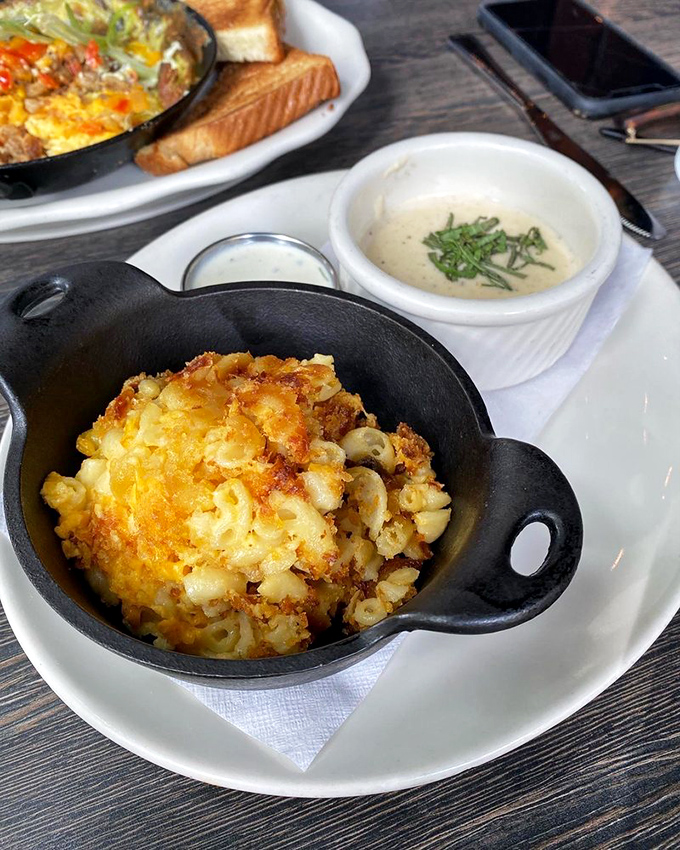 The holy grail of comfort food arrives in its own cast iron throne, crowned with a golden breadcrumb halo that whispers, "Worth every calorie."