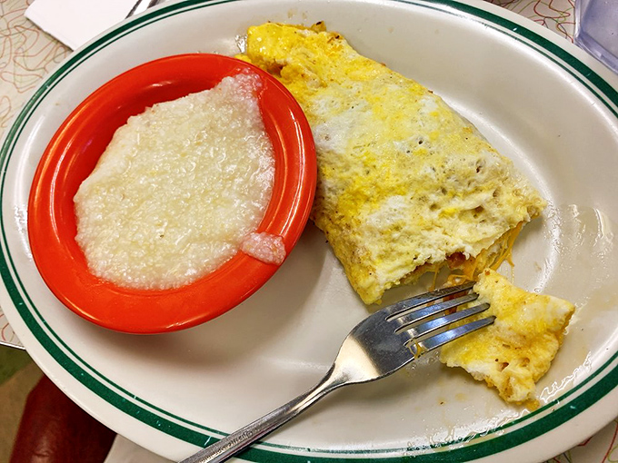 A perfect omelet beside a bowl of creamy grits&mdash;proof that simplicity, when executed flawlessly, is the highest form of culinary art.