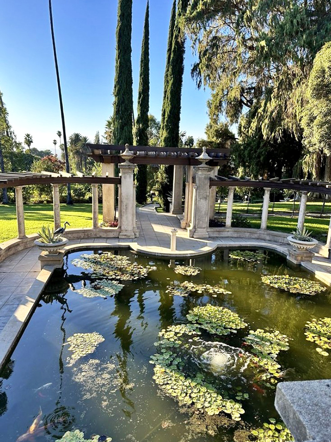 Classical columns frame this reflecting pool where water lilies dance, creating the kind of garden spot that makes smartphone cameras work overtime.