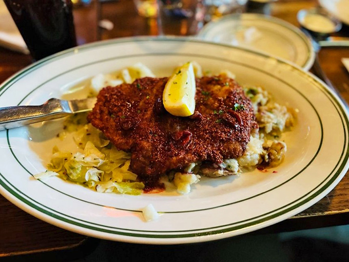 The schnitzel arrives like a golden-brown postcard from the state's German heritage, resting on a bed of cabbage that didn't know it could be this happy.