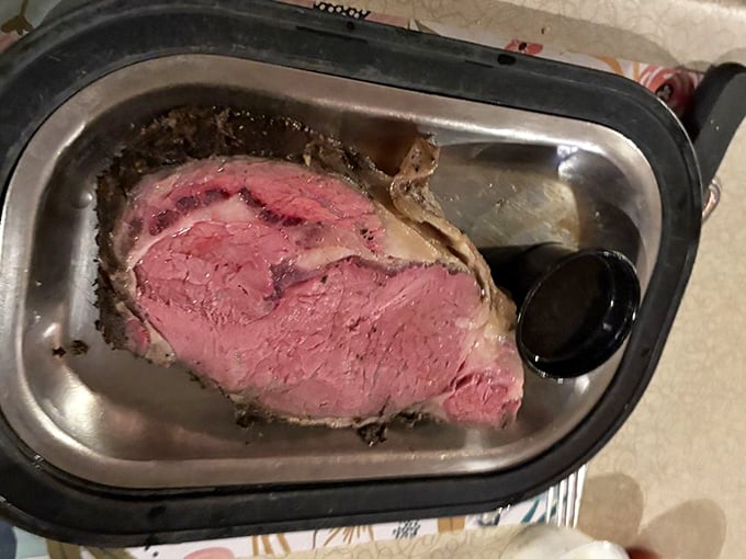 The prime rib arrives like royalty on its silver platter, a glorious monument to beef that makes vegetarians nervously reconsider their life choices.