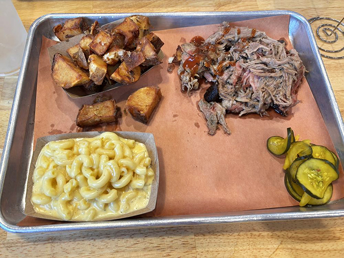 A tray of pulled pork that makes you wonder why you ever wasted time eating anything else. The pickles provide necessary moral support.