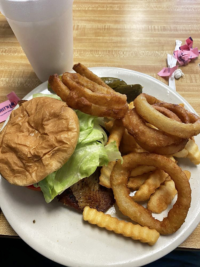 The burger that launched a thousand napkins. Those onion rings aren't just sides—they're golden halos of crispy perfection that deserve their own moment of silence.