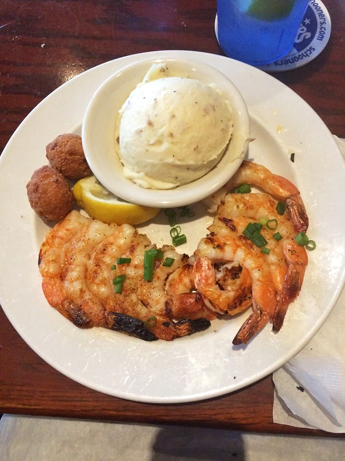 Perfectly grilled Gulf shrimp with hush puppies and creamy sides – proof that sometimes the simplest preparations let seafood's natural sweetness shine brightest.