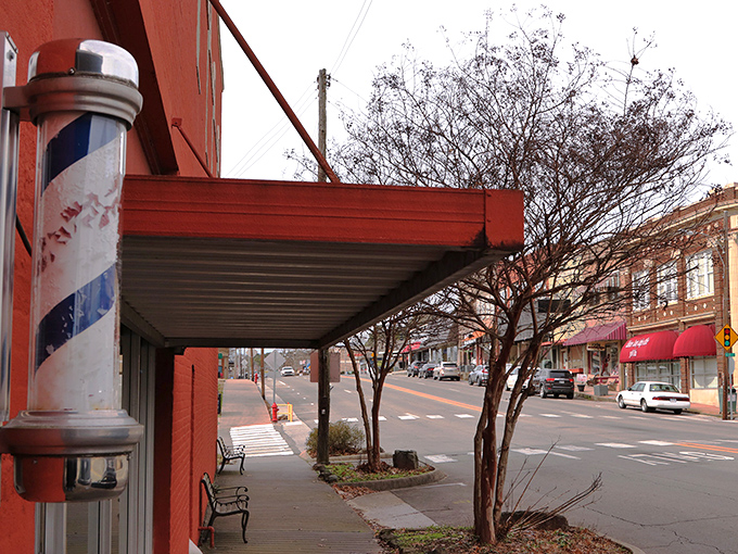 Classic barbershop poles and covered sidewalks create an atmosphere where strolling replaces rushing and conversations happen spontaneously.