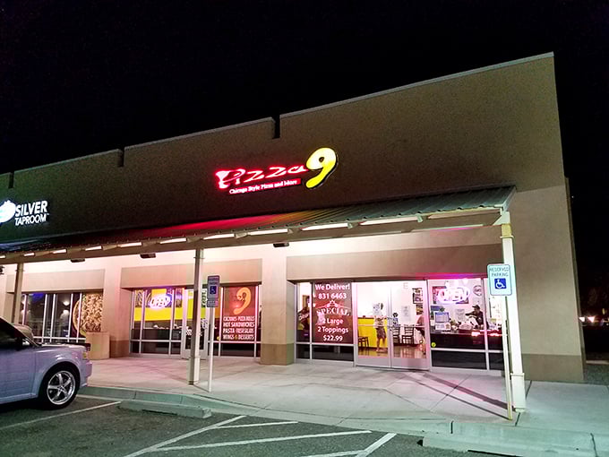 Pizza 9's night glow beckons hungry travelers like a neon lighthouse. "Harbor your hunger here," it seems to say.