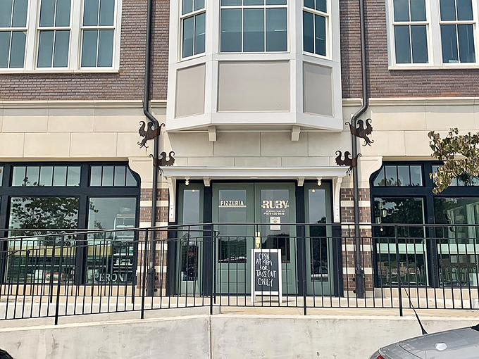 This humble blue building houses the kind of pizza magic that turns strangers into regulars with just one bite. 