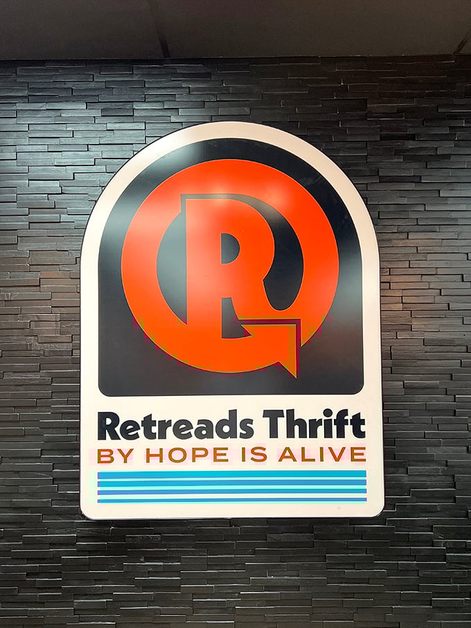 The sleek Retreads logo against textured black wall feels more boutique than bargain bin. Thrifting has officially gone upscale!