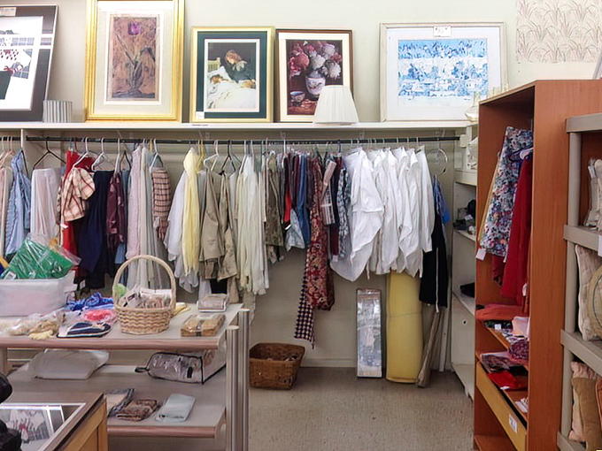 Neatly arranged racks and framed artwork give this thrift shop a curated boutique feel.