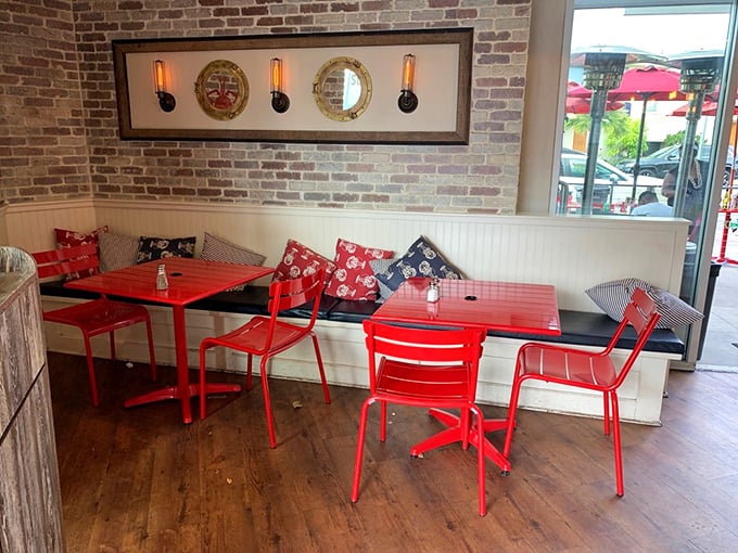 Nautical meets cozy at Lobster West's interior, where porthole mirrors and brick walls create a maritime vibe. Those red chairs aren't just stylish&mdash;they're a beacon for seafood lovers.