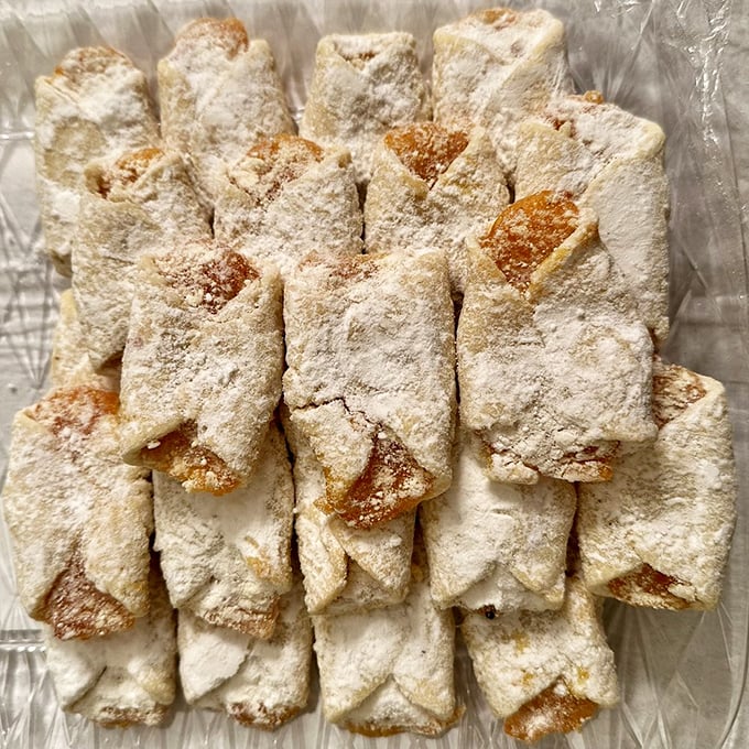 These powdered delights aren't just cookies; they're edible pillows hiding fruit centers, standing in formation like delicious little soldiers awaiting inspection.