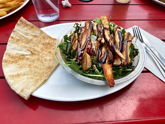 For those seeking lighter fare, this arugula salad with grilled chicken offers a momentary reprieve from burger indulgence&mdash;though you'll be eyeing your neighbor's plate.