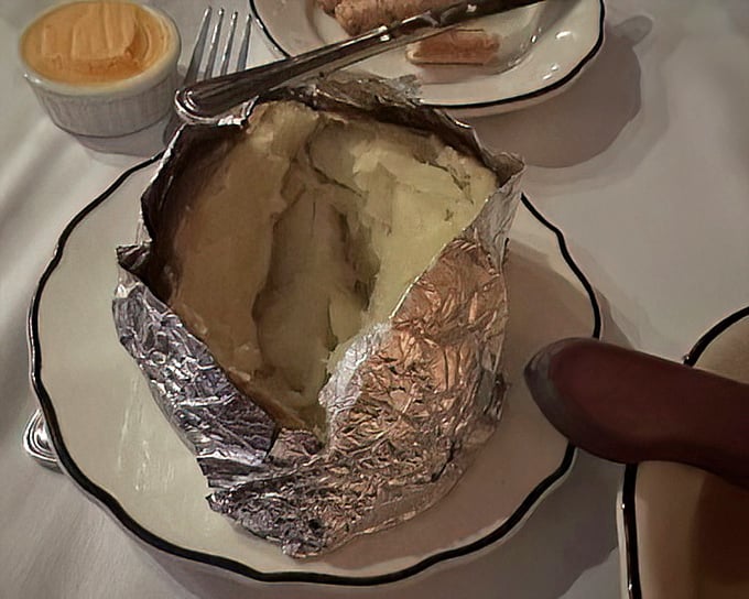 The humble baked potato, elevated to art form. Wrapped in foil like a present waiting to be unwrapped, buttery treasure inside.