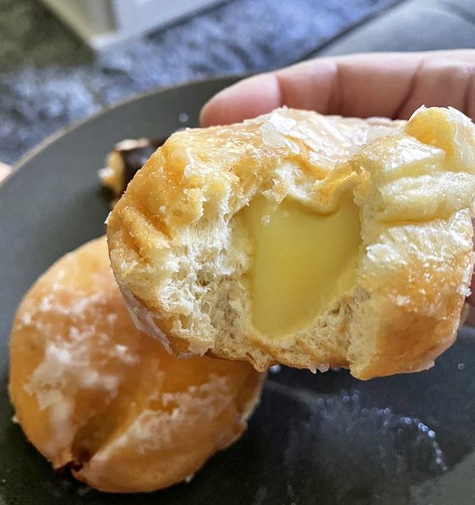 The Bavarian cream-filled donut reveals its treasure—a golden exterior giving way to a center of vanilla custard that's worth setting the alarm for.