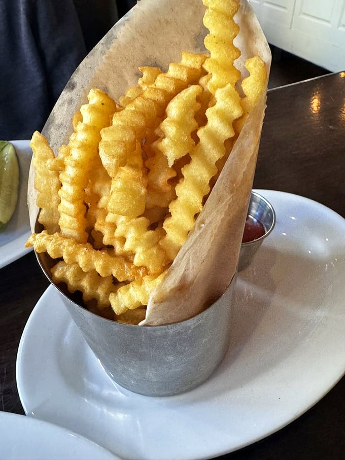 Fries served with theatrical flair in their metal cone chariot. That little cup of ketchup knows it's just an optional accessory.