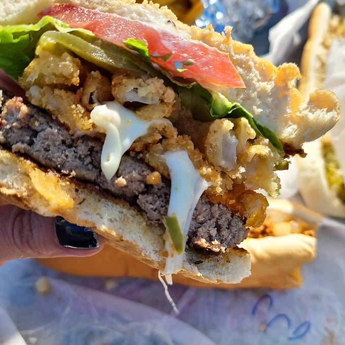 This isn't just a burger &ndash; it's an architectural marvel of beef, cheese, and toppings that requires both hands and complete dedication.