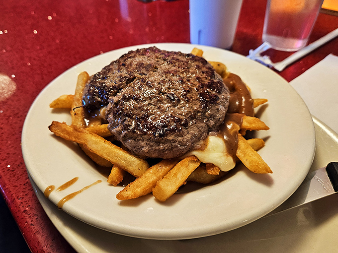 This burger patty lounging on a bed of gravy-soaked fries isn't just a meal&mdash;it's a declaration of delicious independence from diet culture.