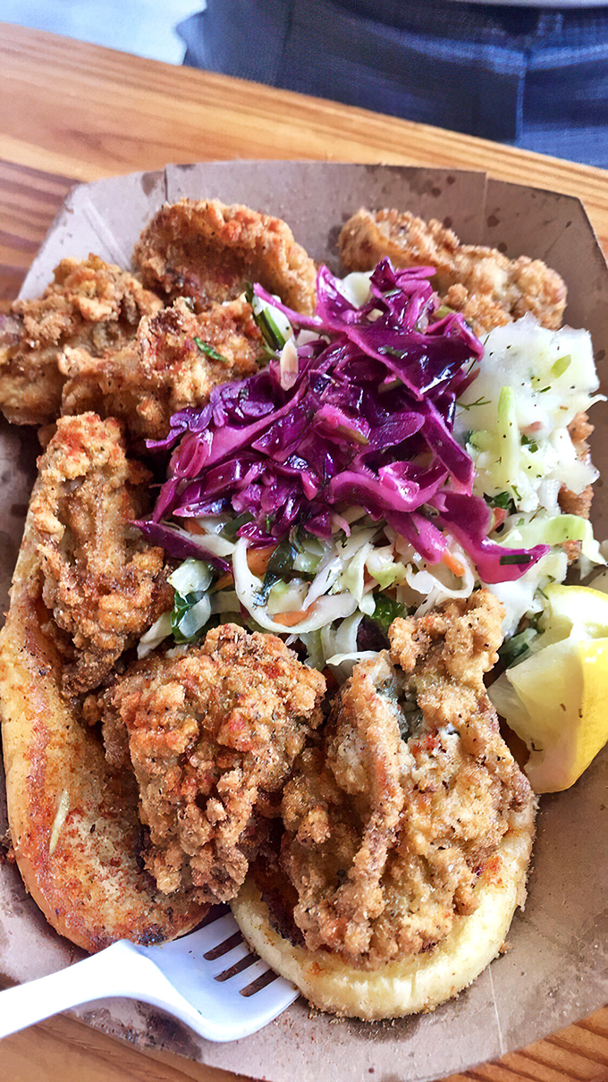 The catfish sandwich comes adorned with vibrant slaw that cuts through richness like a well-timed joke at a tense dinner party.